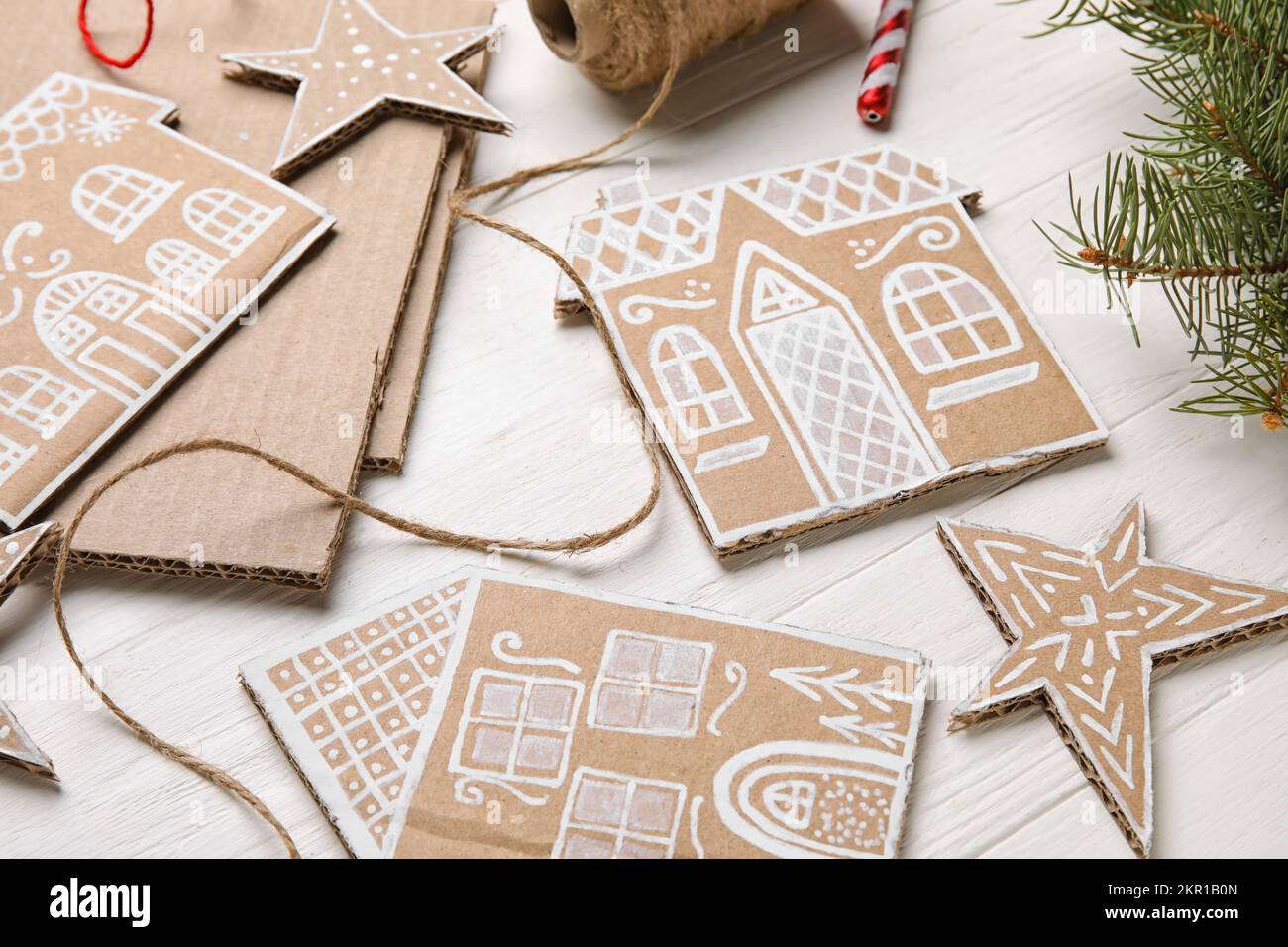 Christmas cardboard stars and houses on white wooden background ...