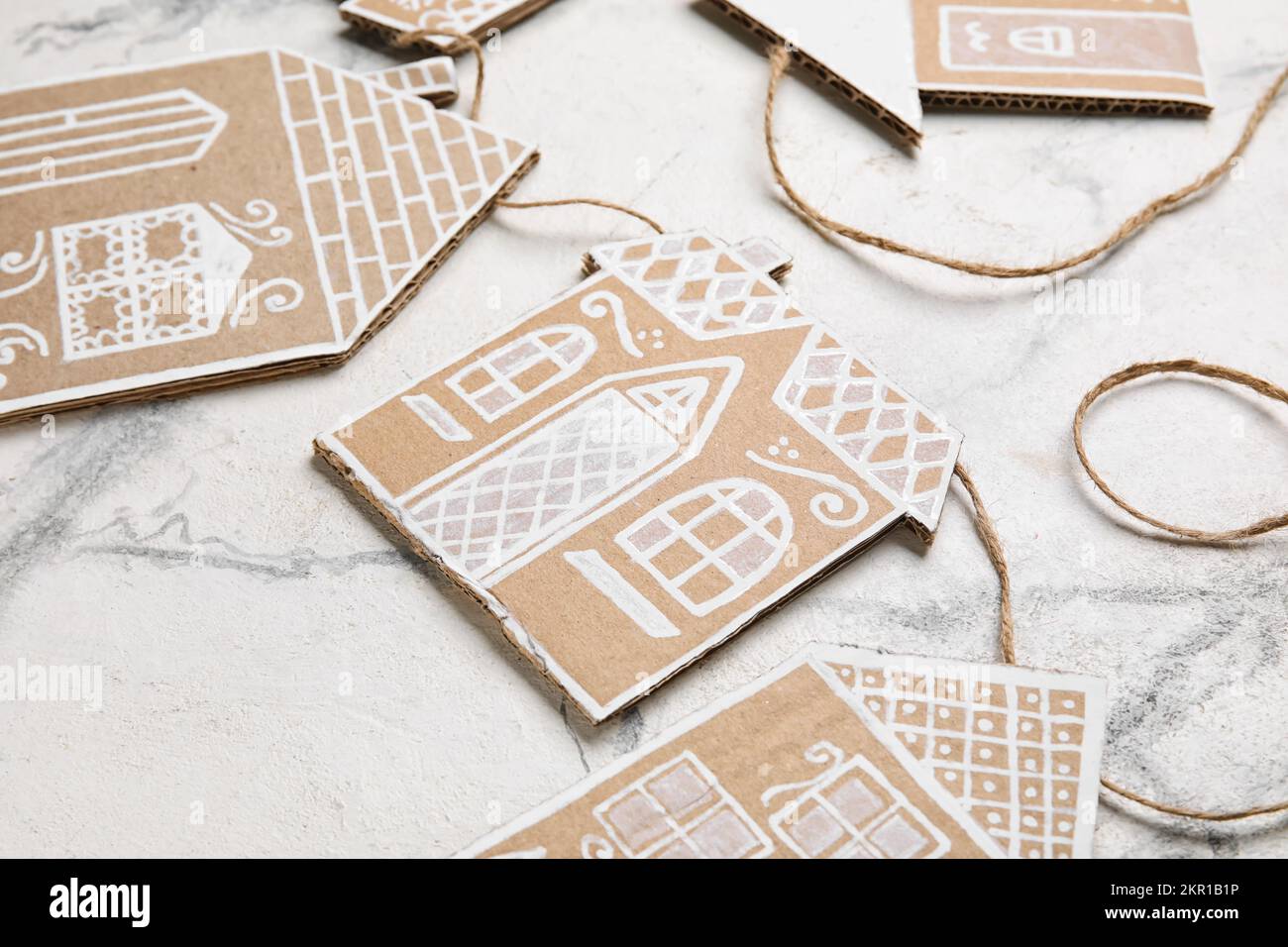 Christmas cardboard houses with rope on light background Stock Photo ...