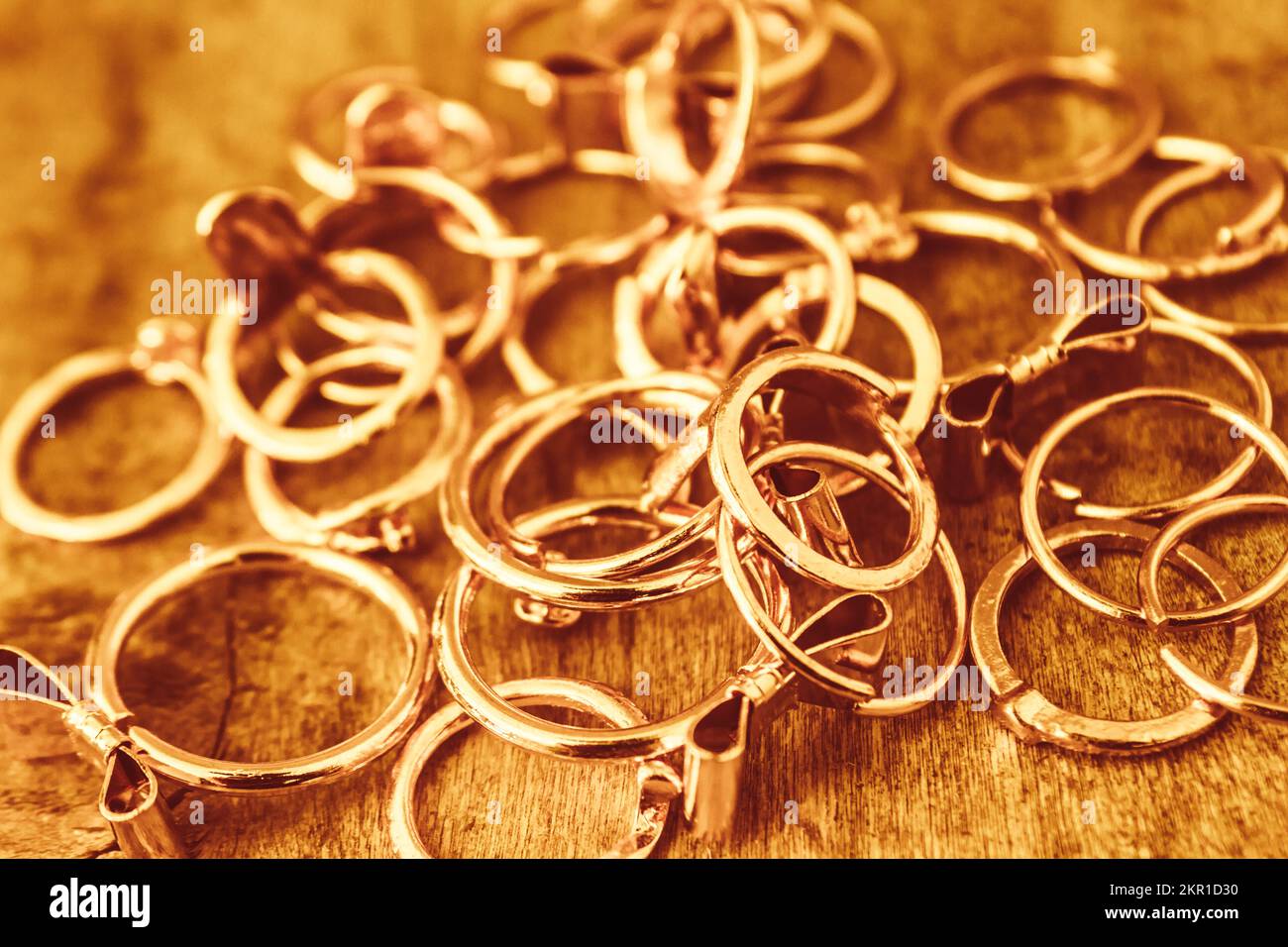 Rustic object art on a messy pile of round golden rings on wooden ...