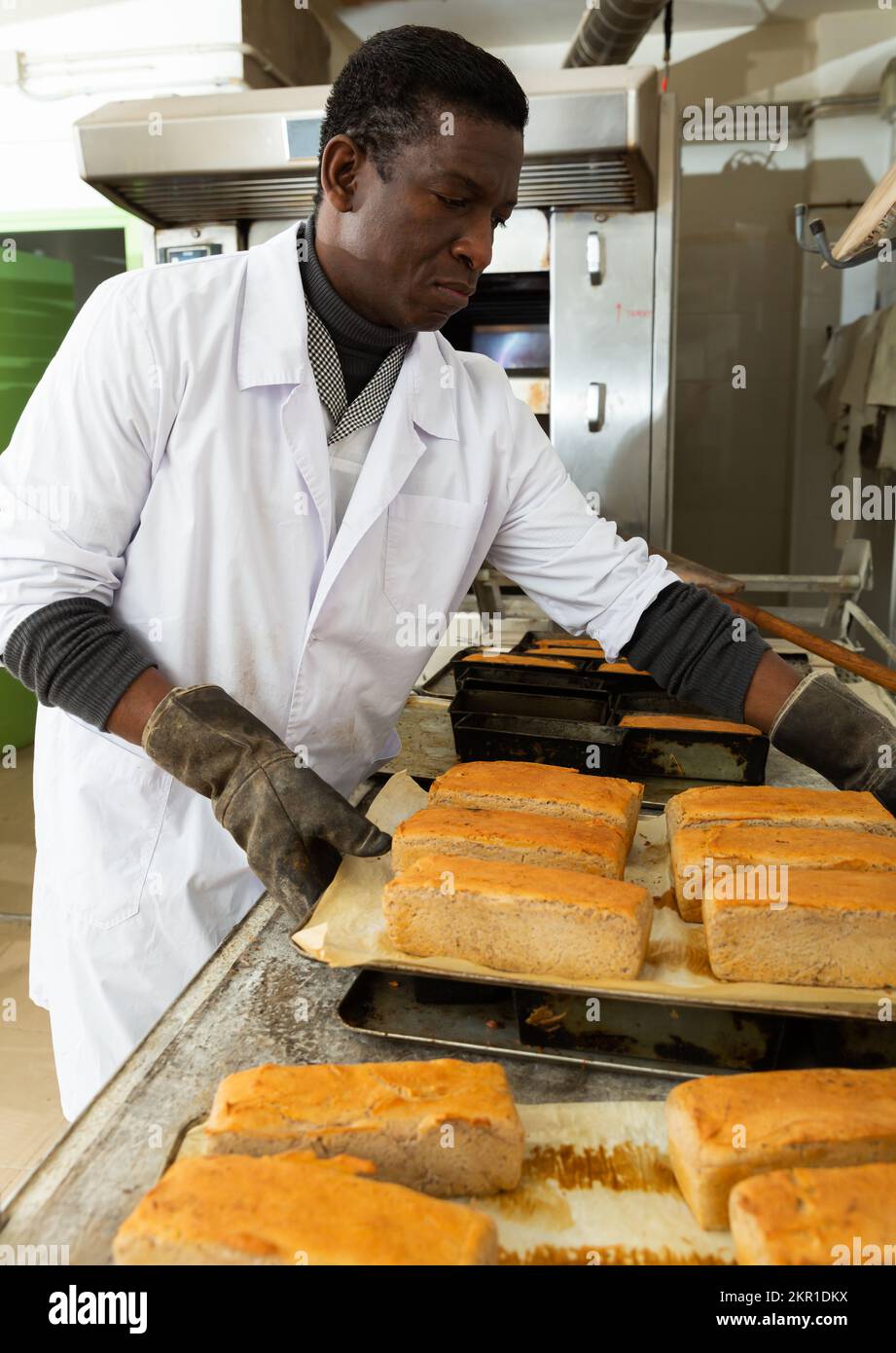 African baker taking out bread from baking molds Stock Photo - Alamy