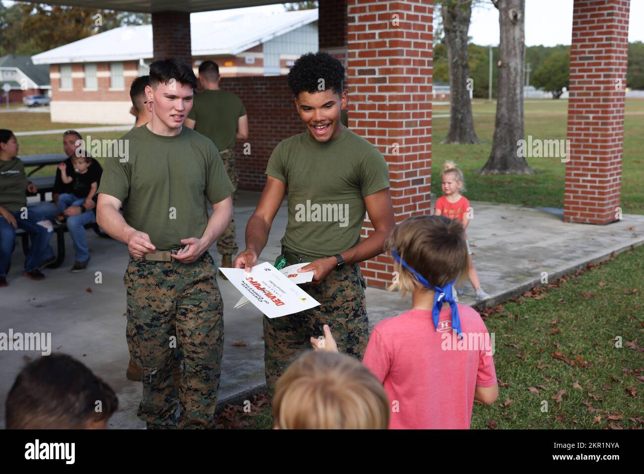 U.S. Marines hand out certificates of completion to children during the ...