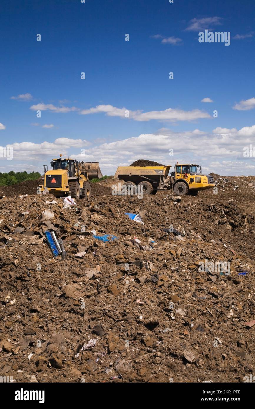 Loader and Volvo A250 dump truck on mound of debris at waste management ...