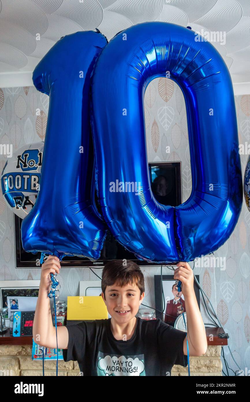 A boy poses with blue helium filled balloon on his 10th birthday Stock ...