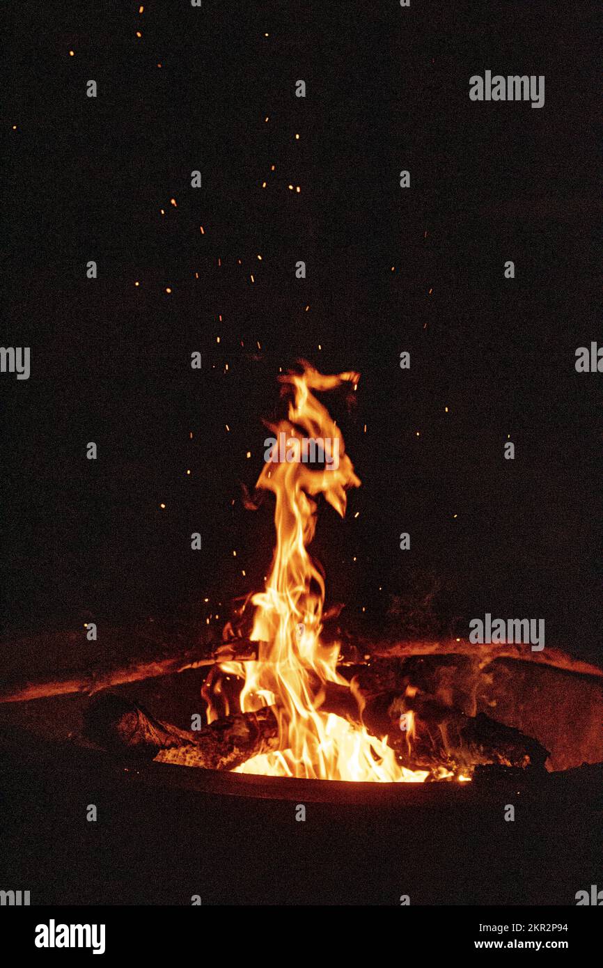 Camping Around a Campfire Showering Sparks into the Air Stock Photo - Alamy