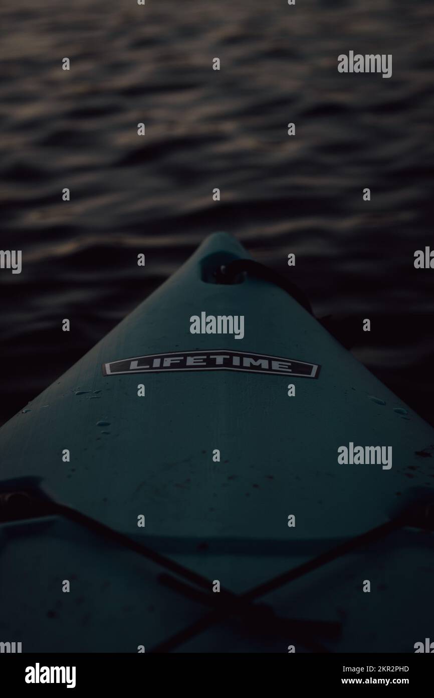 Blue Kayak Peacefully Floating in a Lake After Sunset Stock Photo - Alamy