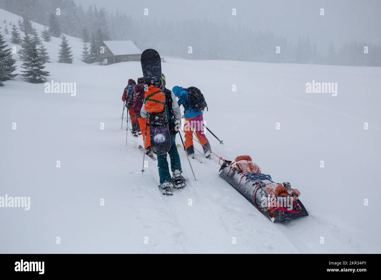 Ski rescuers pull a special sled (akya) on a snow in the mountains with ...