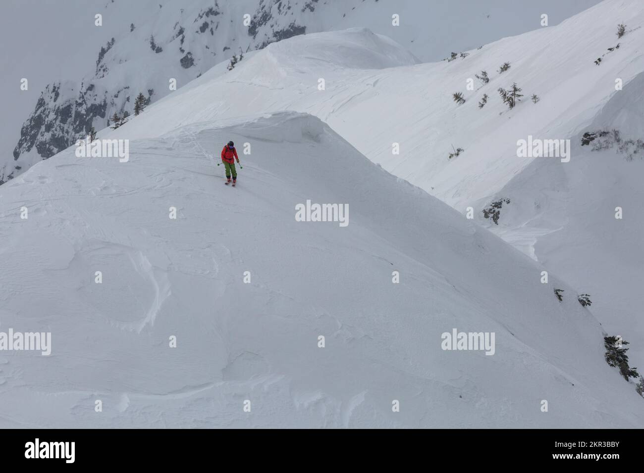 A skier descends a steep frozen slope in the mountains, an adrenaline ...