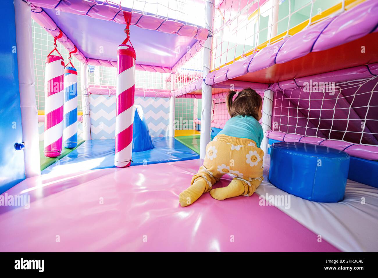 Happy girl crawls at indoor play center playground Stock Photo - Alamy