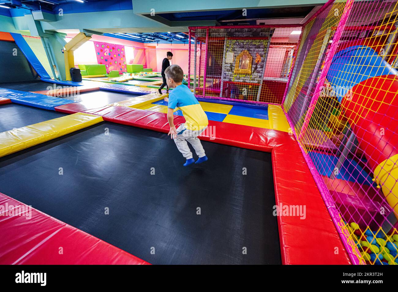 Happy kids playing at indoor play center playground. Boy jumping on ...
