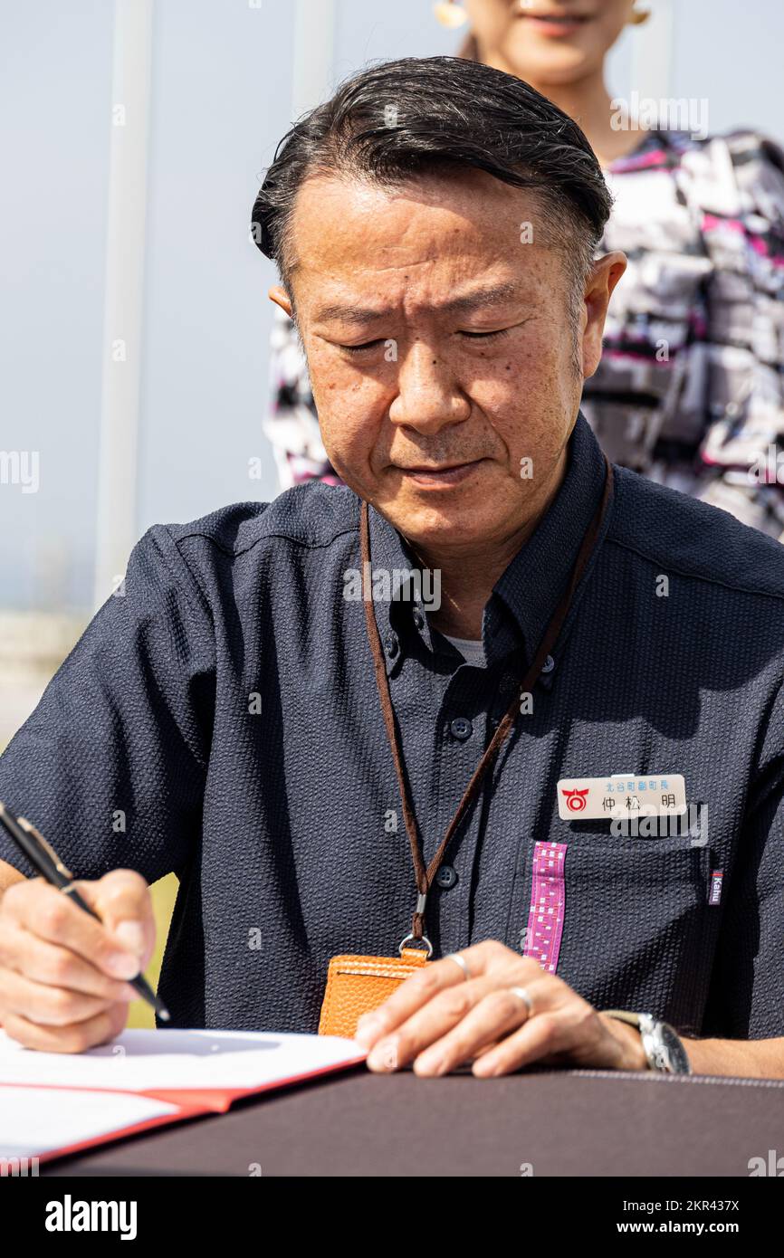 Akira Nakamatsu, the vice mayor of Chatan, Okinawa, signs a Local ...
