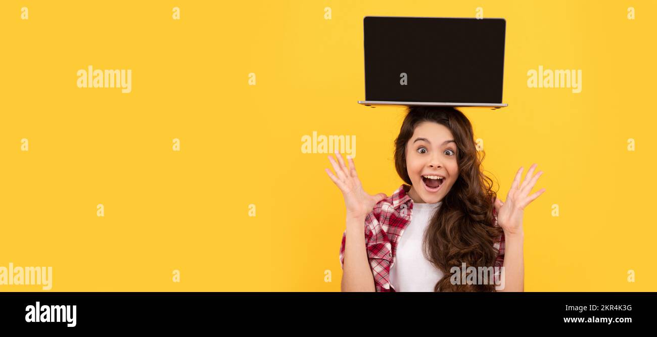 amazed smart kid with laptop on head presenting school online lesson ...