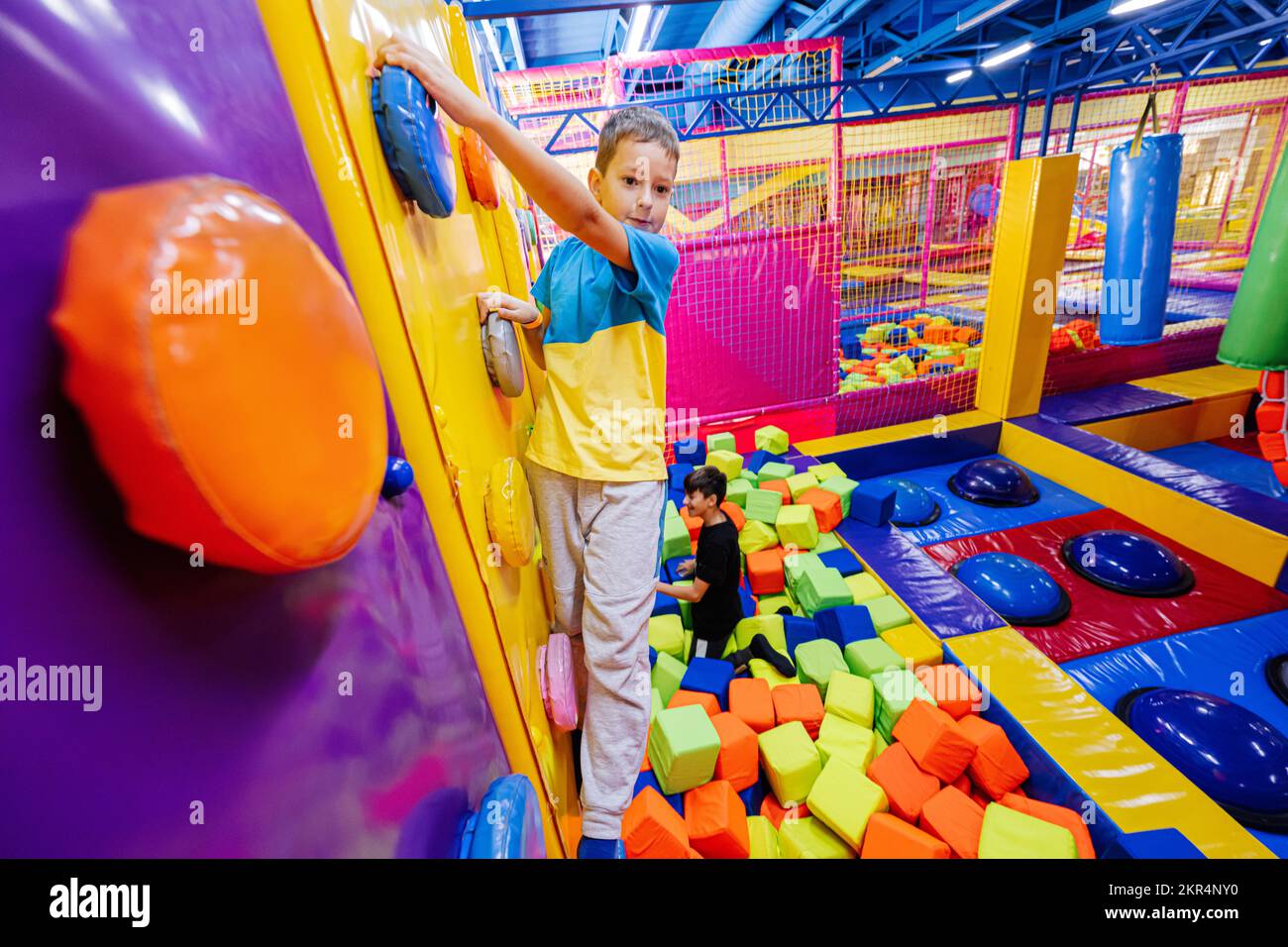Happy kids playing at indoor play center playground, brothers climbs in ...