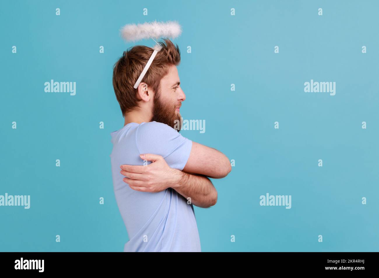Side view of bearded angelic man with holy nimbus standing smiling ...