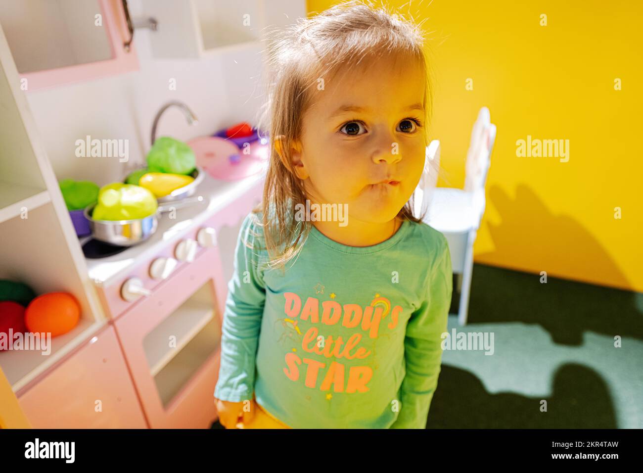 Baby girl playing at indoor kids kitchen playground Stock Photo - Alamy