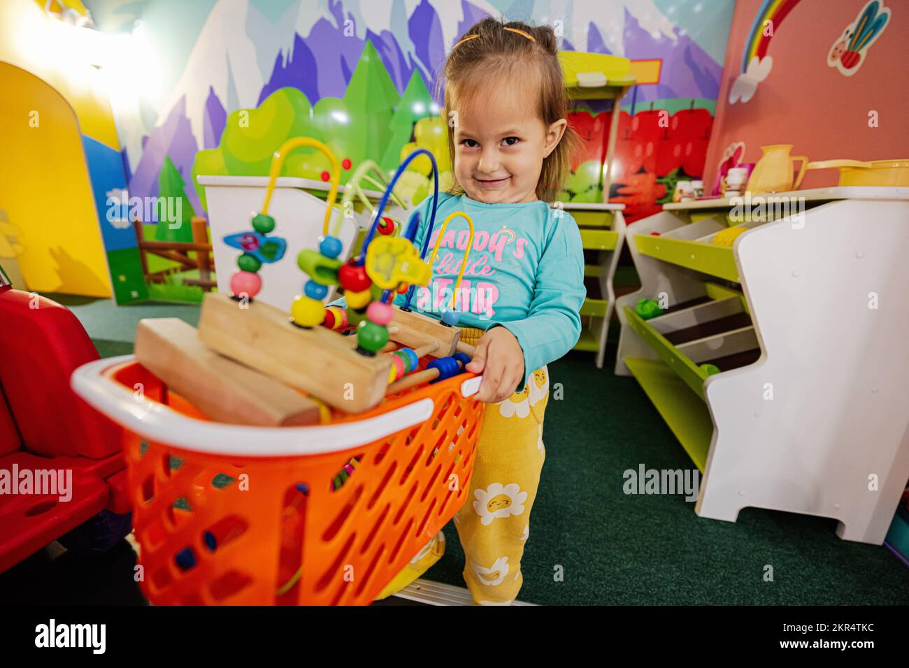 Baby girl playing at indoor kids kitchen playground Stock Photo - Alamy