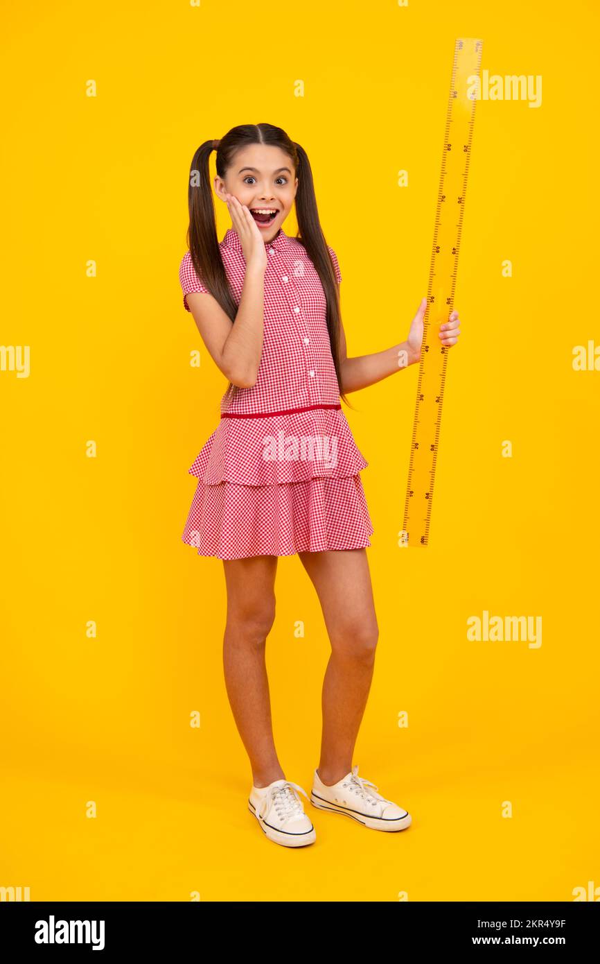 Amazed teenager. School girl holding measure for geometry lesson ...