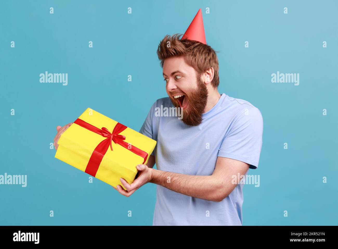 Portrait of extremely happy bearded man being very glad to get present ...