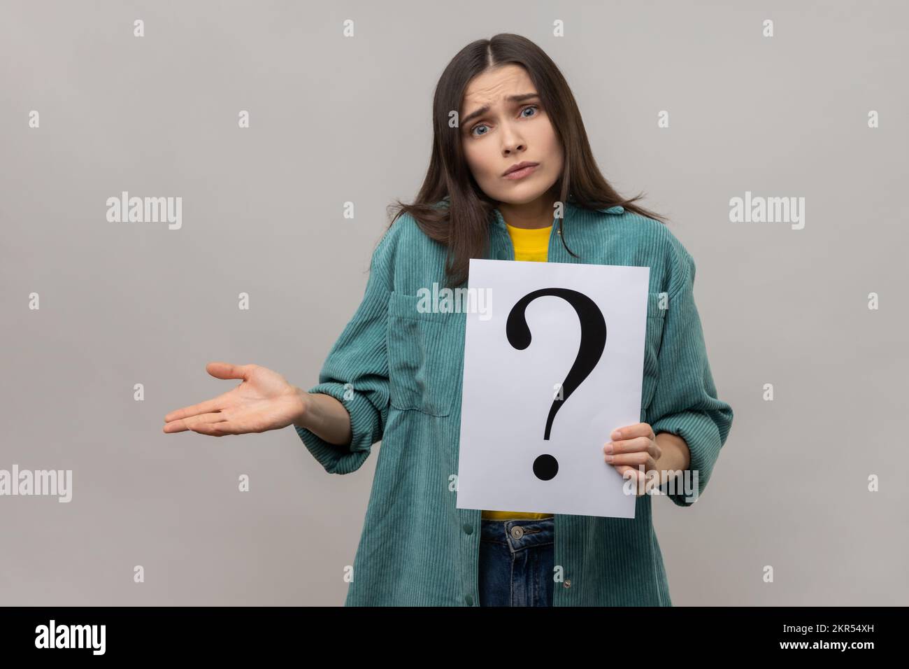 Portrait of confused puzzled woman looking at camera, holding paper ...