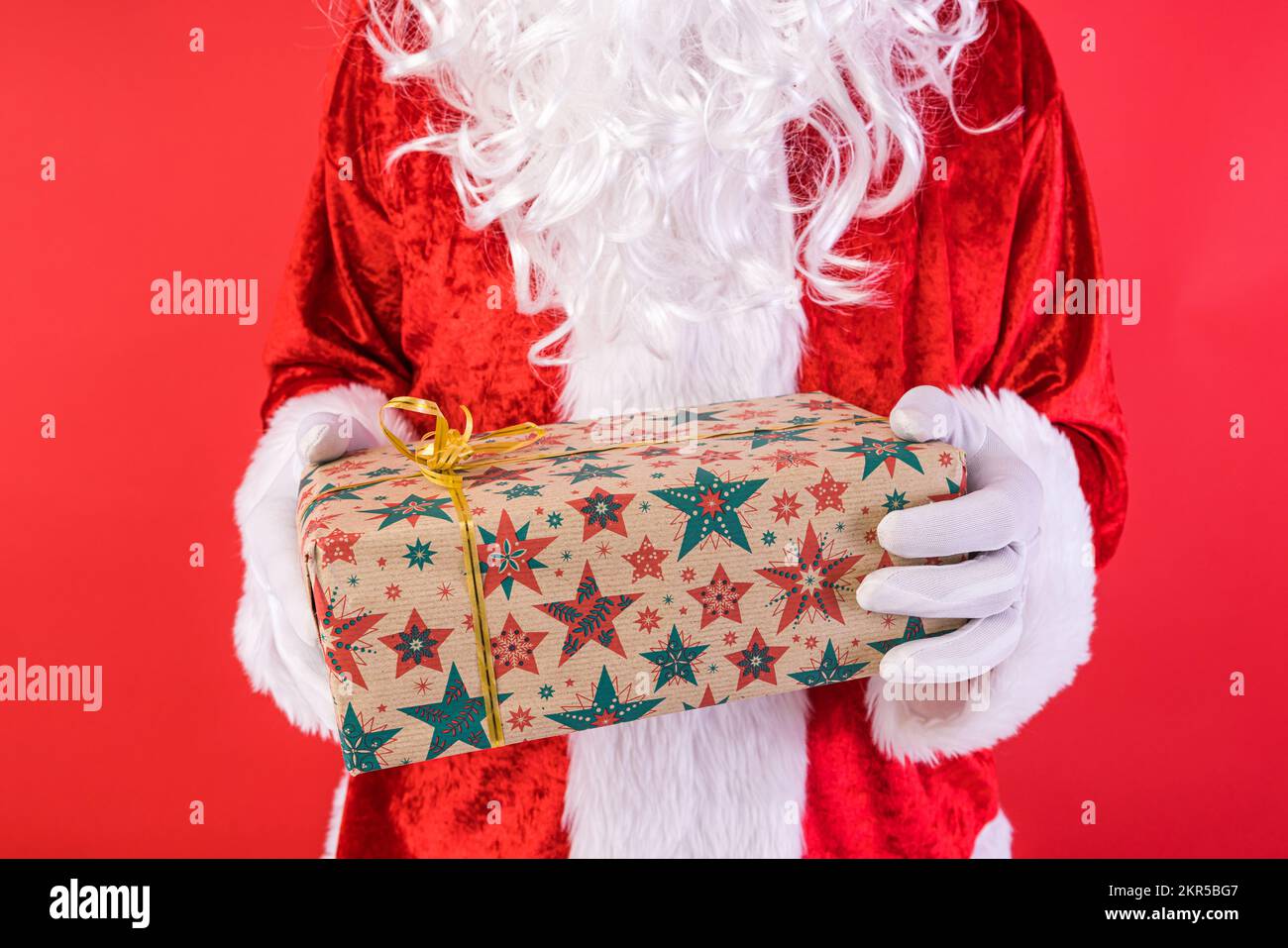 Detail of the hands of a man dressed as Santa Claus with gloves holding ...