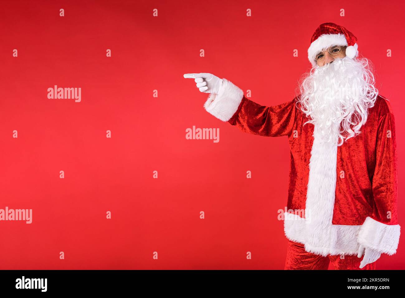 Man dressed as Santa Claus, pointing to the side with his finger, on ...