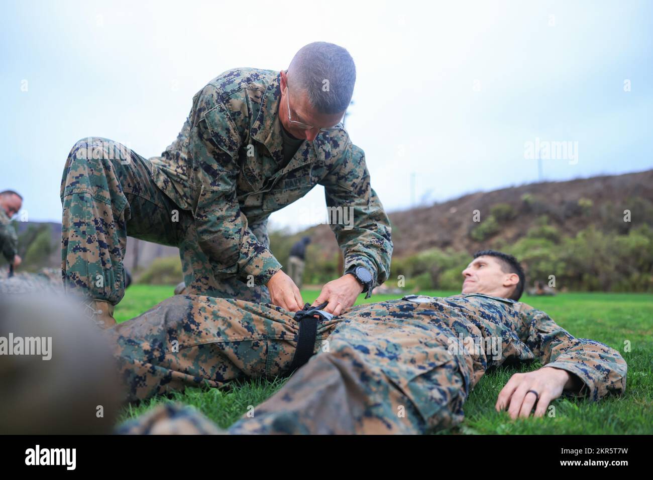U.S. Navy Capt. Henry F. Holcombe, the chaplain for 1st Marine Division, applies a tourniquet on ...