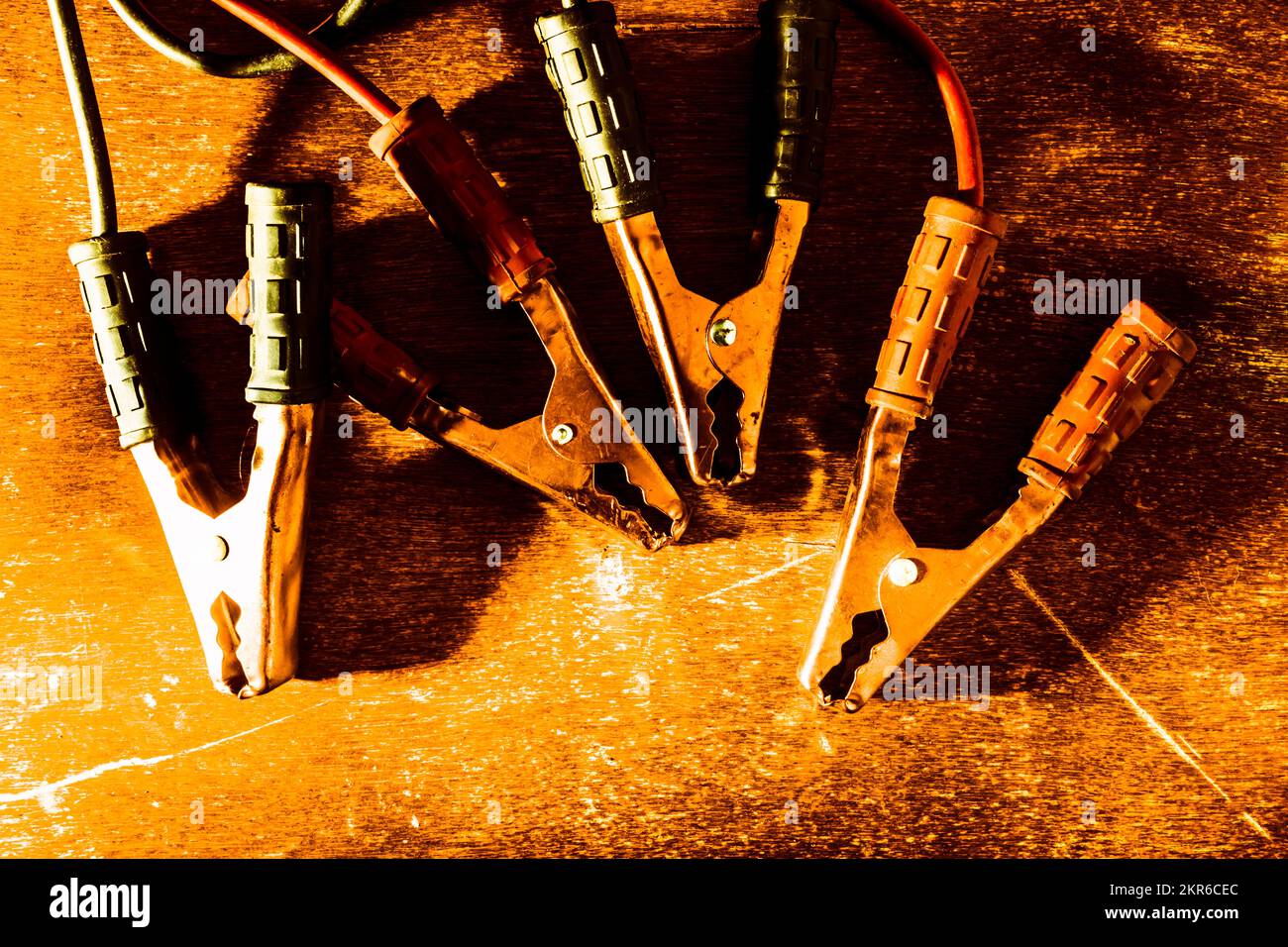 Still life photo on a set of booster cables clamps on rustic wooden ...