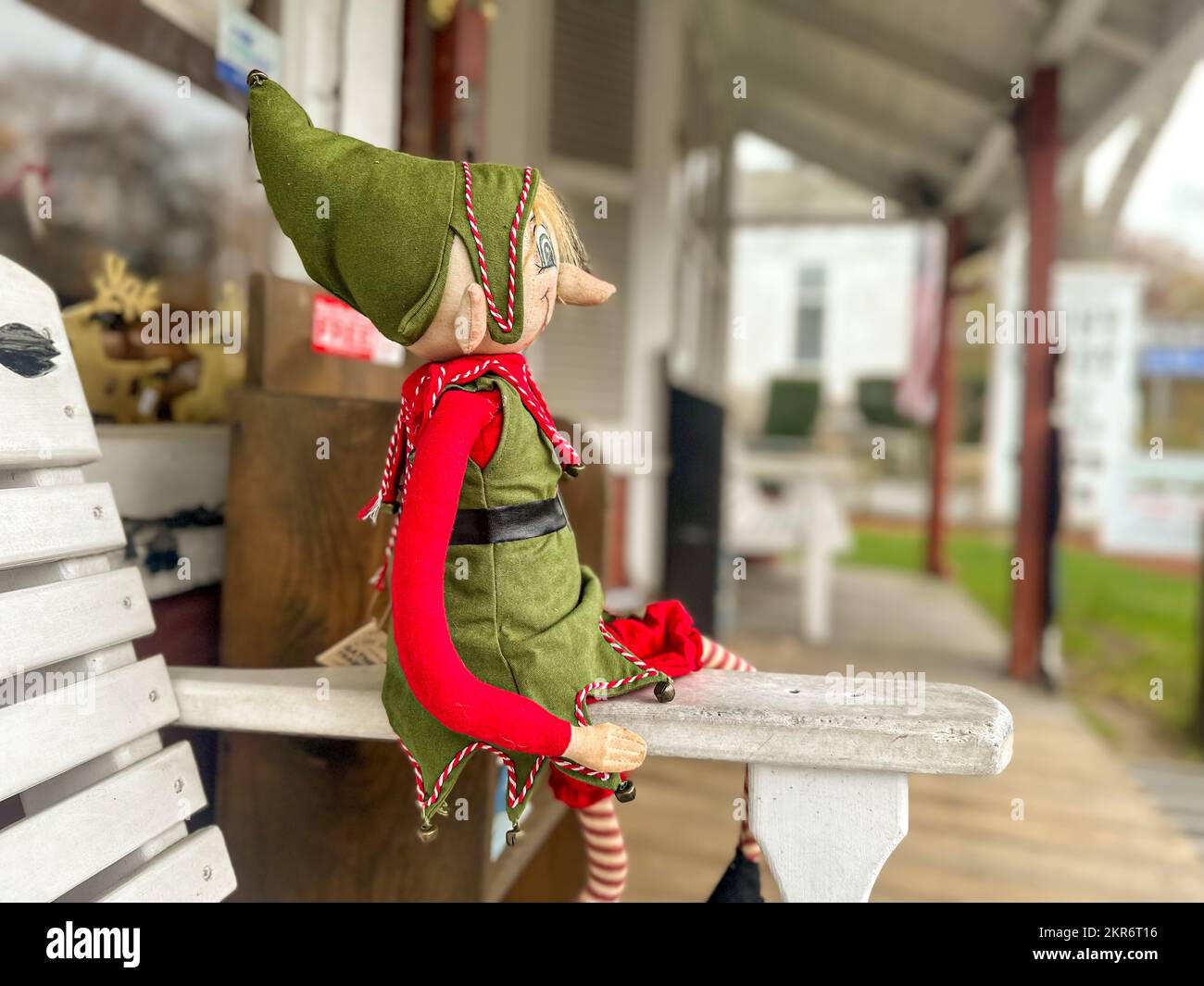 Photo of a holiday Elf sitting on the arm of an outside bench Stock ...