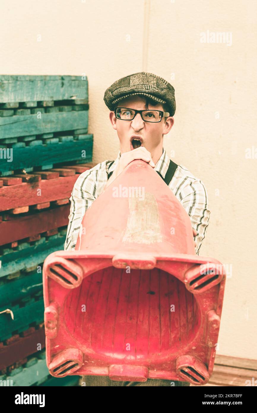 Humorous old photo of a young handsome man sounding out a megaphone ...