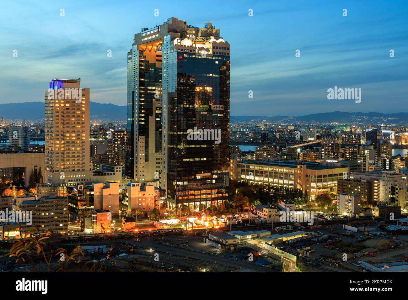 Unique office building towers over low rise cityscape in blue hour ...