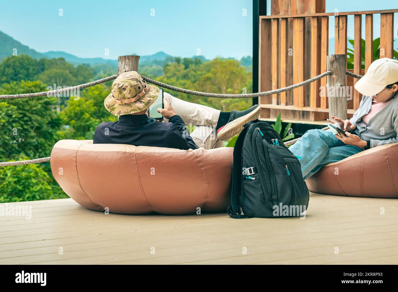 Male tourist wear hat with face mask and his wife use tablet and mobile ...