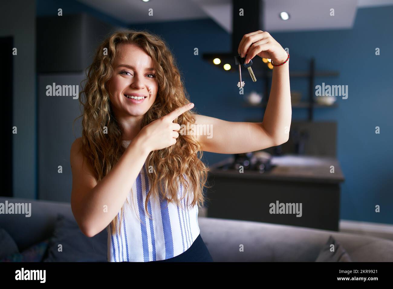 Happy woman showing new house or apartment keys to camera in modern ...
