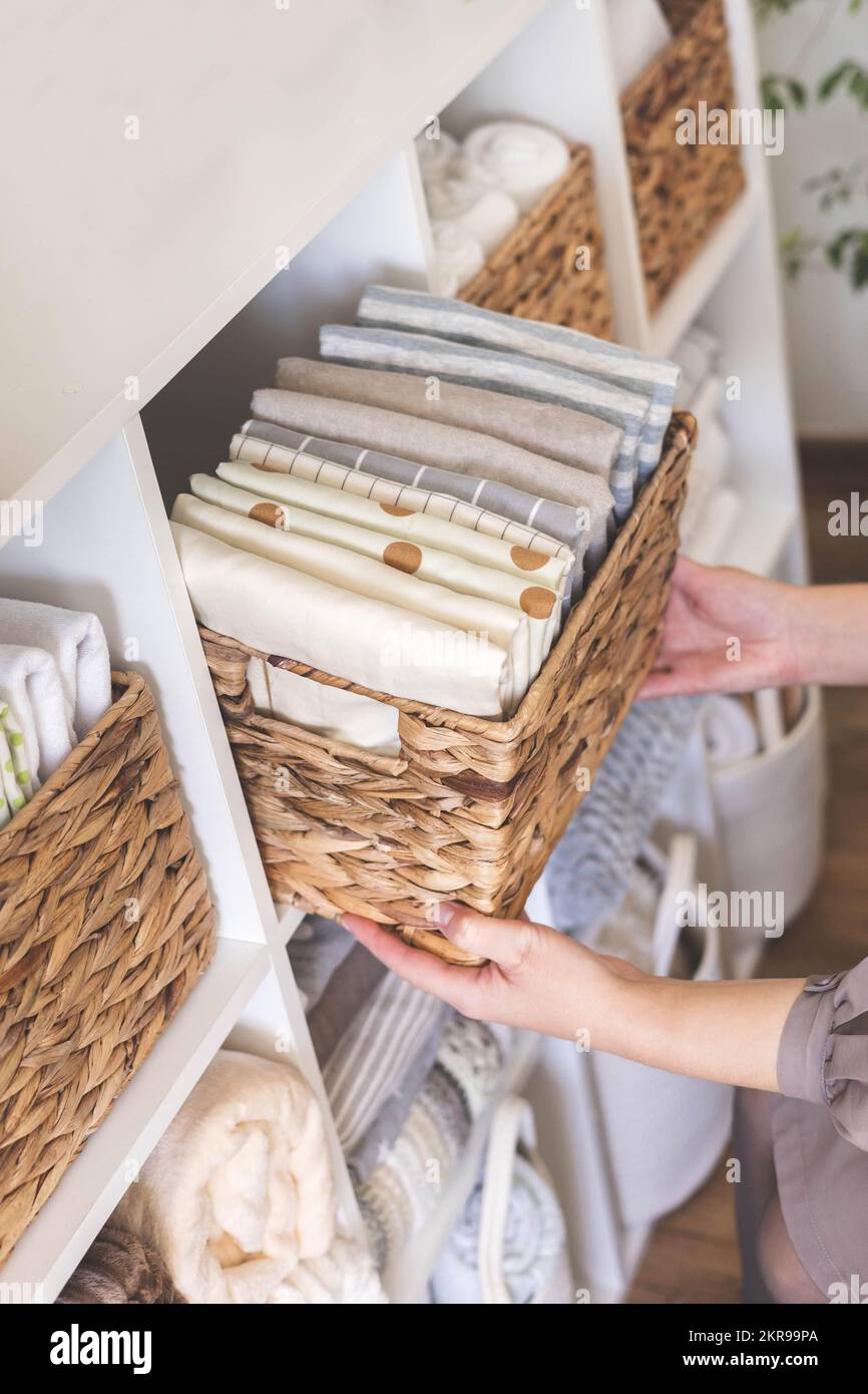 Hands of a housewife woman pulling a container of linens from a closet ...