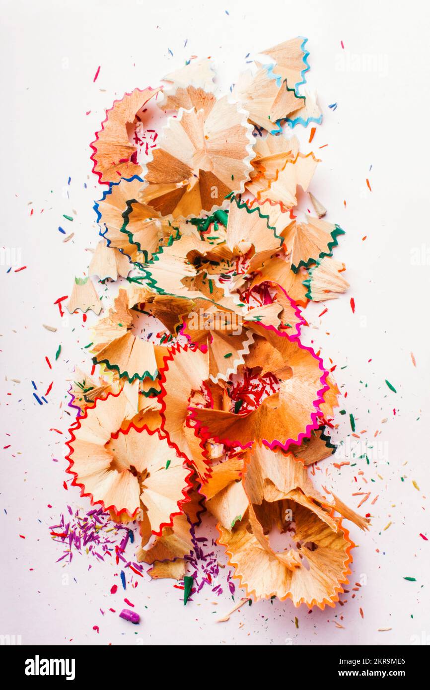 Art school scene on a heap of coloured pencil shavings on white ...