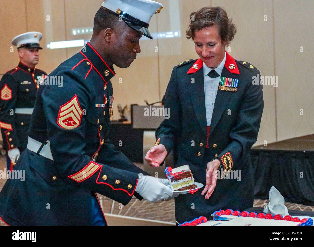 U.S. Marine Corps Staff Sgt. Jimmy Saintjean passes the birthday cake to Maj. Margaret Jones ...