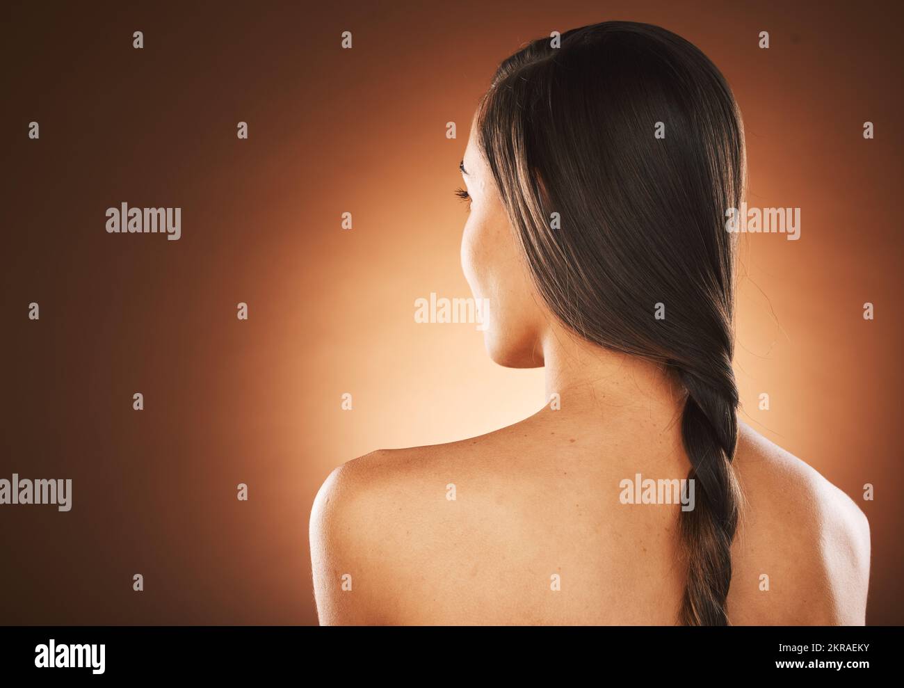 Woman, back or hair style on orange background in studio in keratin ...