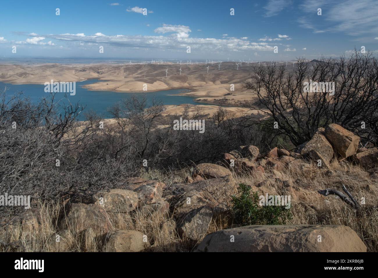 A view out over Los Vaqueros reservoir and hills dotted with wind ...