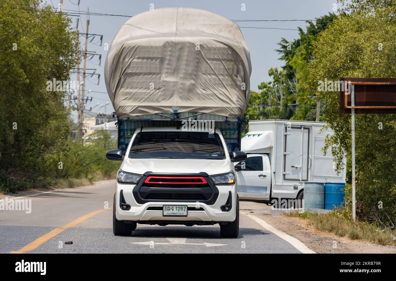 A pick-up fully loaded with drinking water in a plastic bottles covered ...