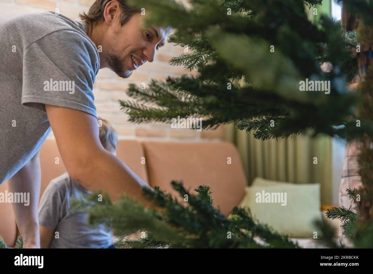 Family assembling, shaping hook-in artificial Christmas Tree at home ...