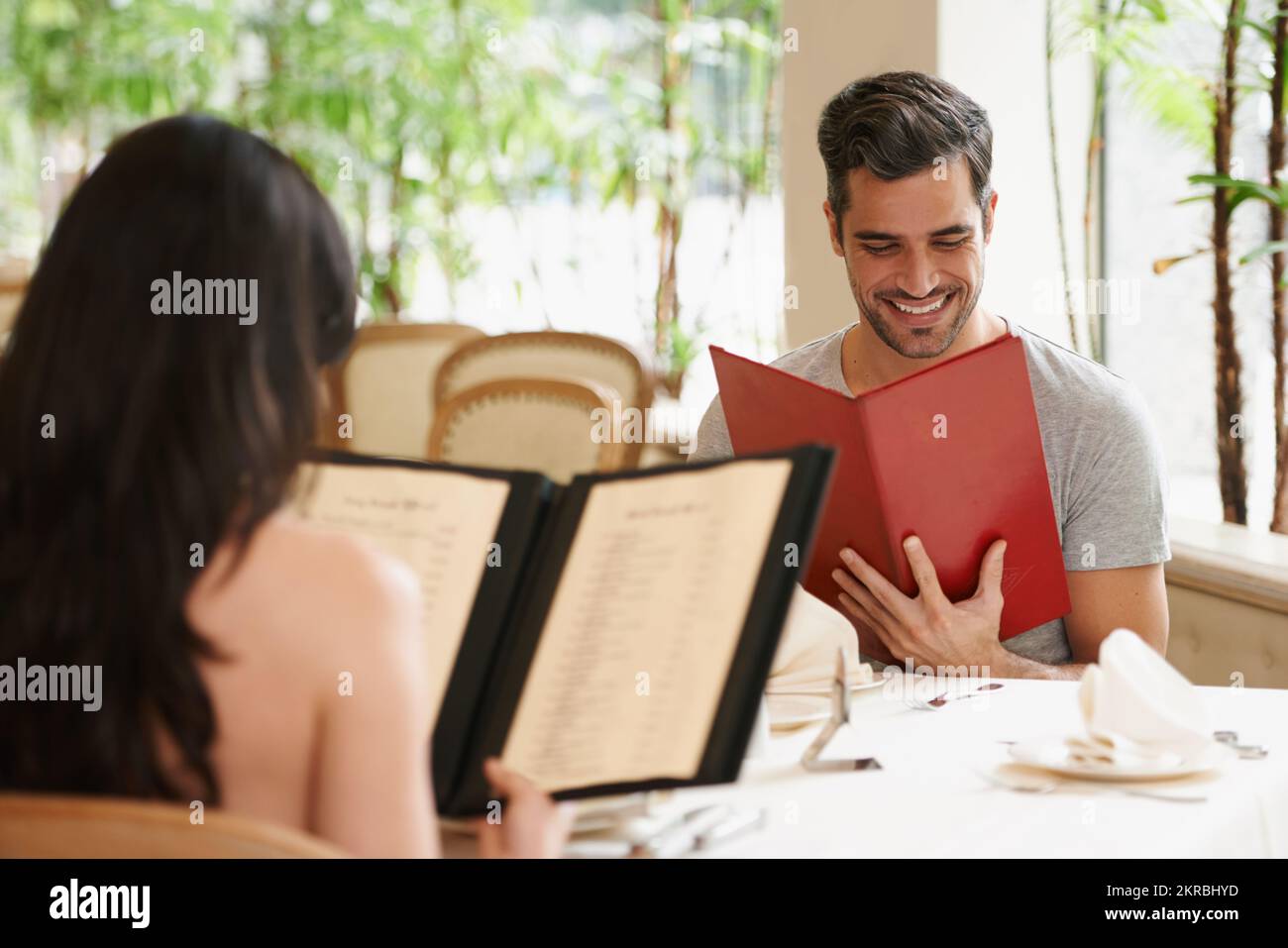 It all looks so yummy. A happy young couple looking at their menus at a ...