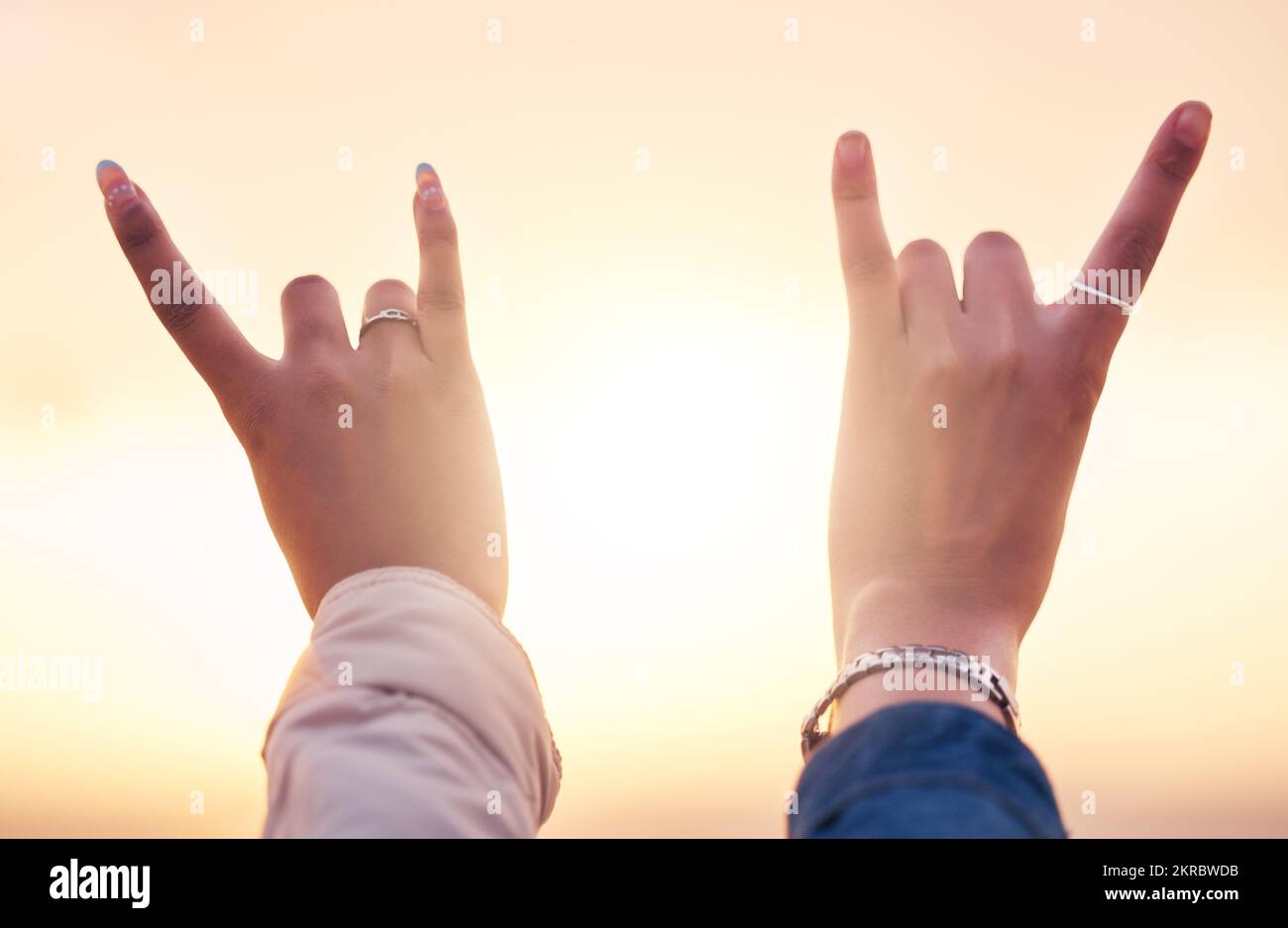 Friends hand, rock and roll sign, freedom and sunset outdoor in summer ...