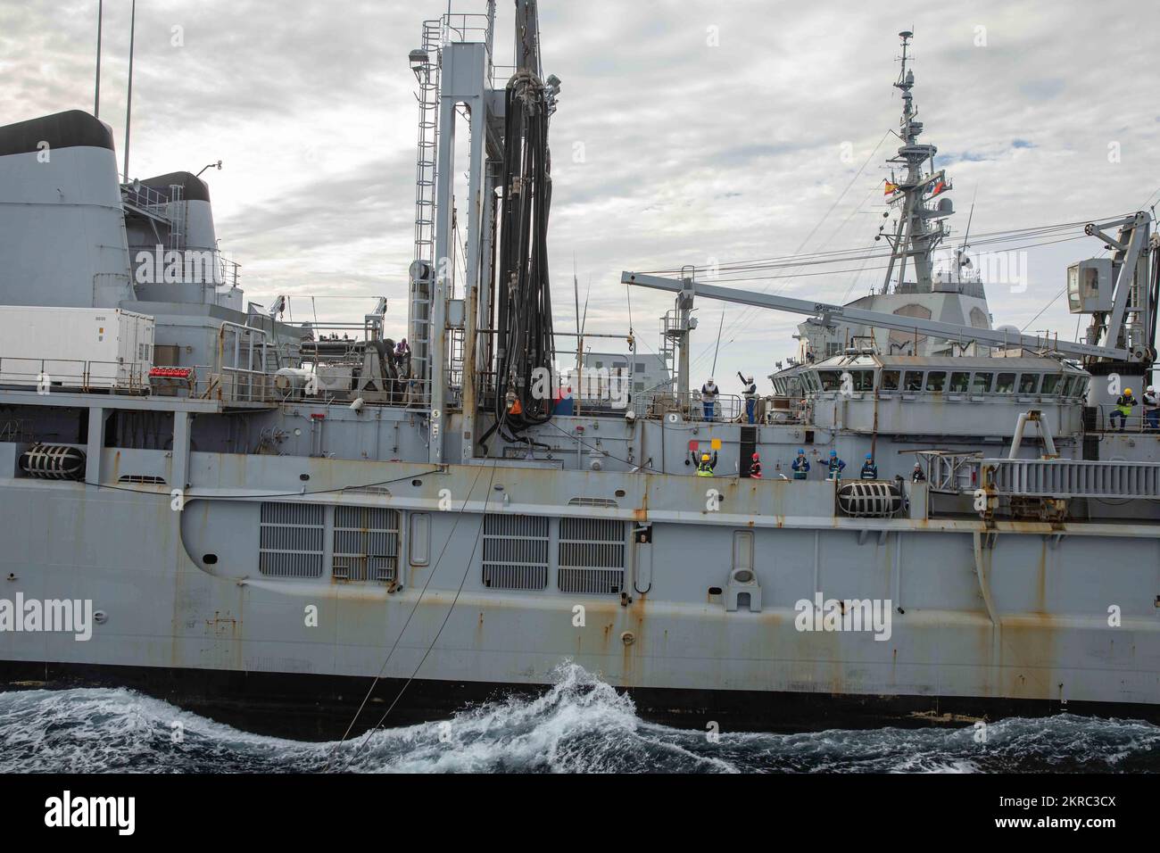 A signalman aboard the French tanker FS Somme (A 631) communicates with ...