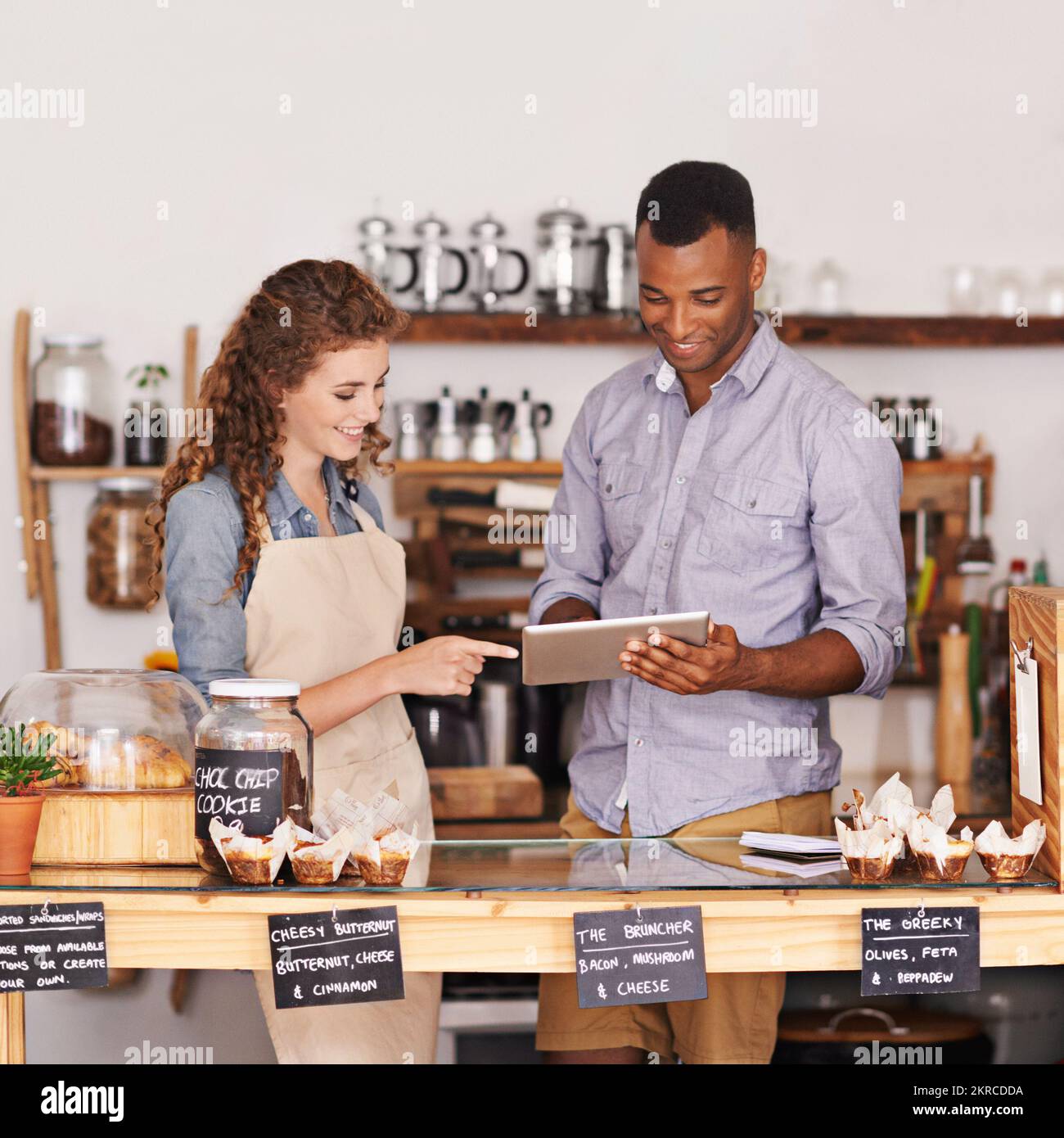 The coolest cafe in town. young baristas using a digital tablet in a ...