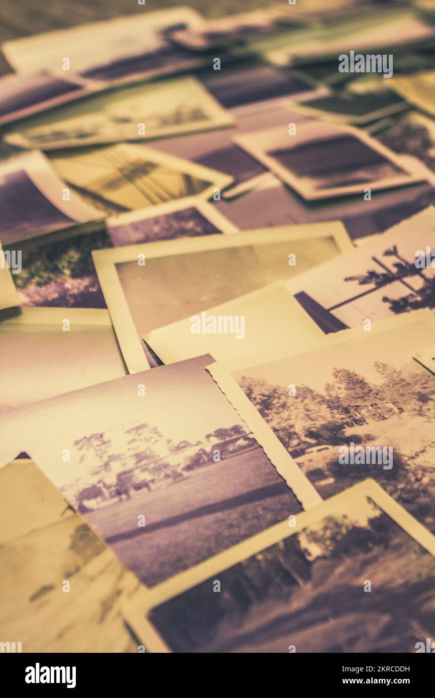 Low view of a desk covered in old faded film photography of vintage ...