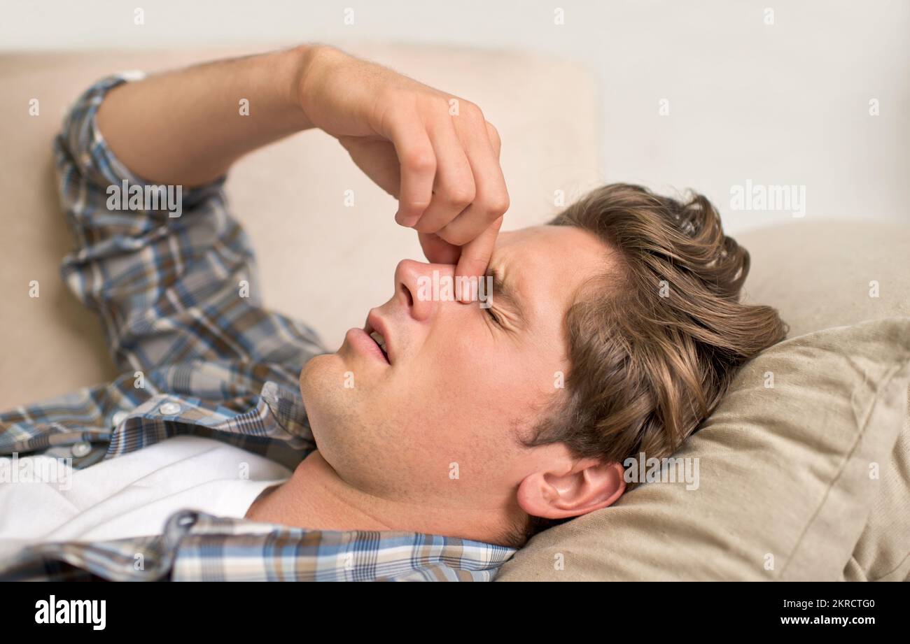 My sinuses are so blocked. A young man holding his head in pain Stock ...