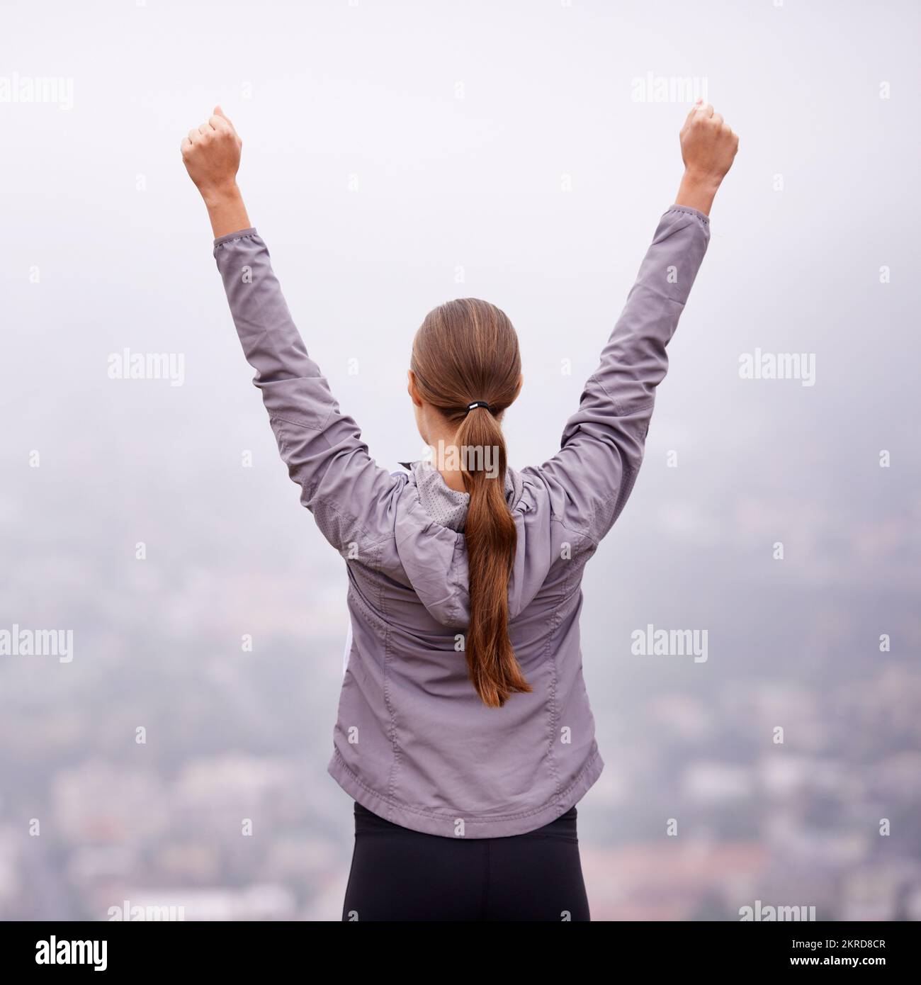Starting her morning on a high note. Rearview shot of a woman training ...