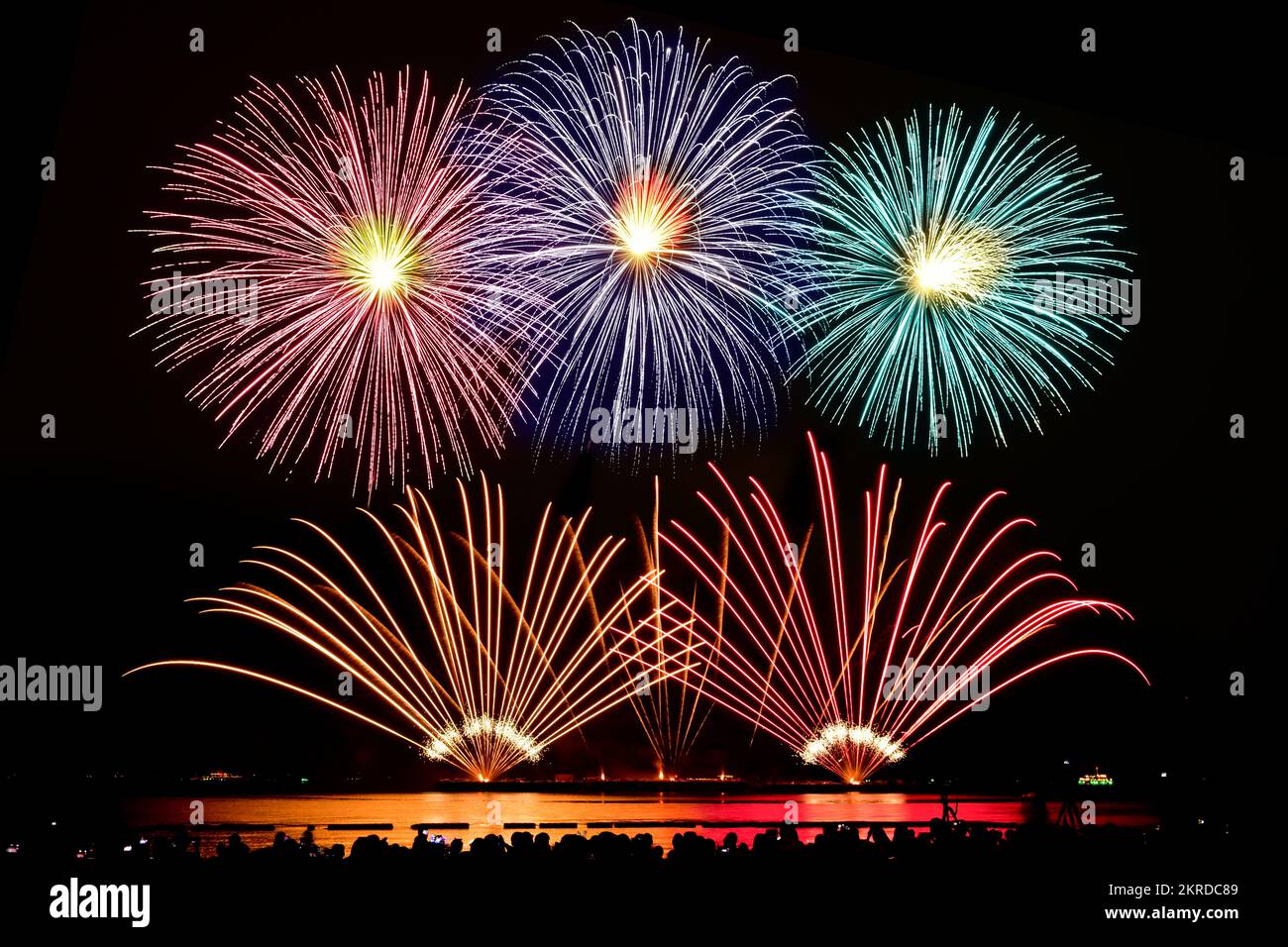 People capturing a fireworks shows with their mobile phone. Colorful ...