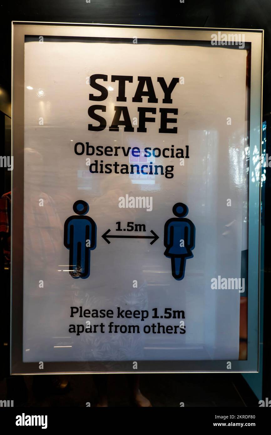 A social distancing warning sign in a shop window in the street of an ...