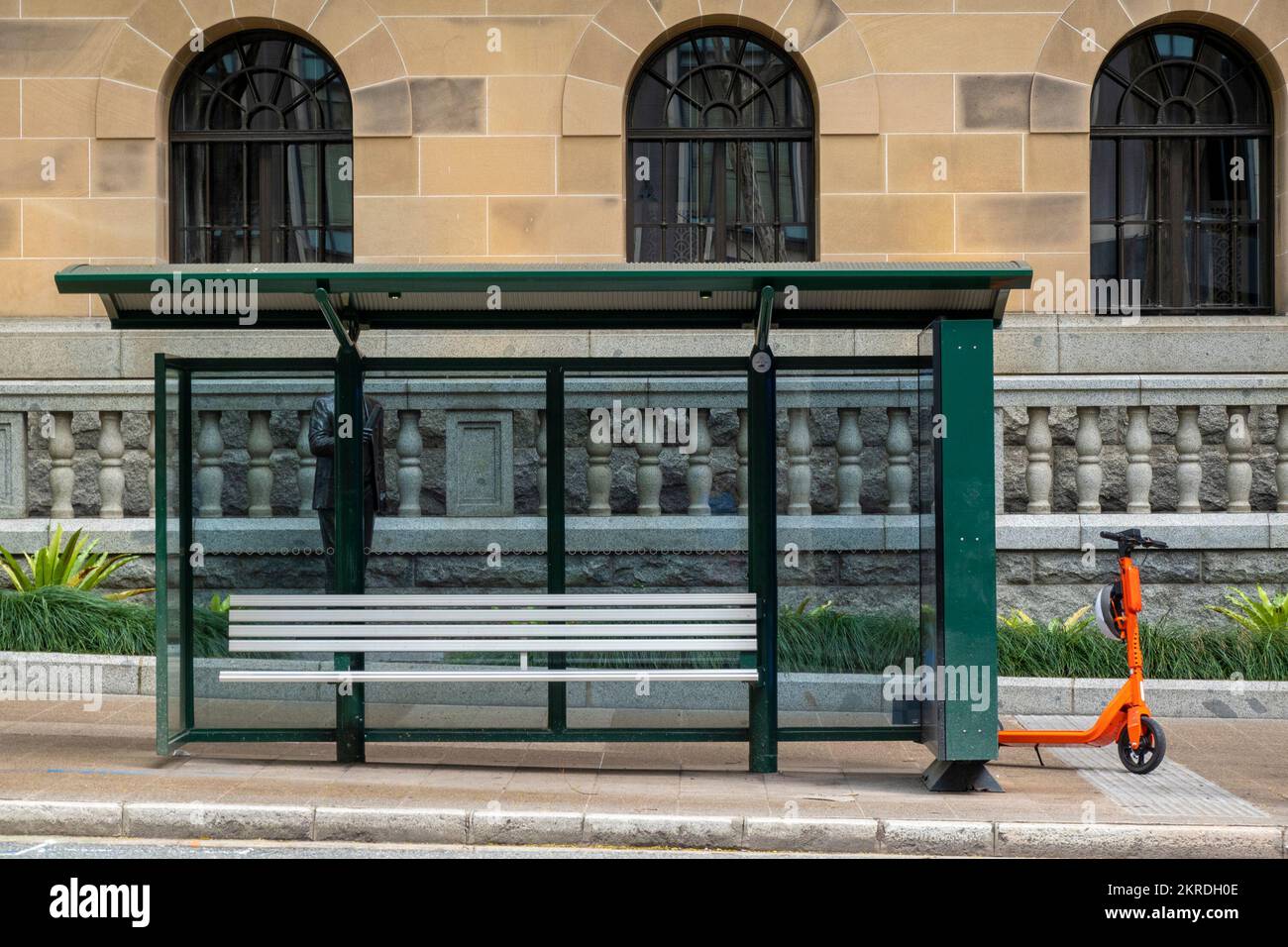 A public bus stop in a city street in front of an historic building ...