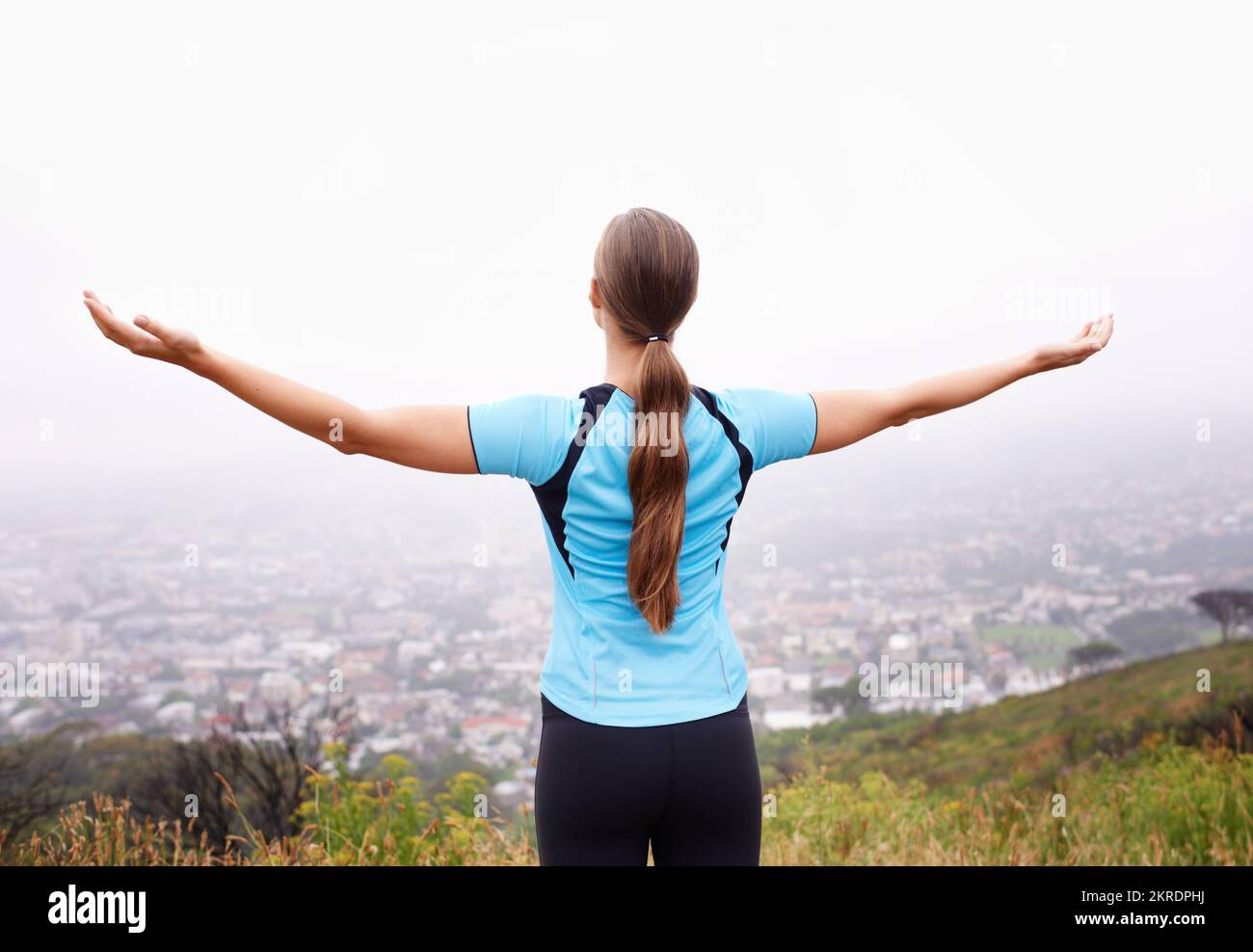 Embracing the morning. a young woman training outdoors with her arms ...