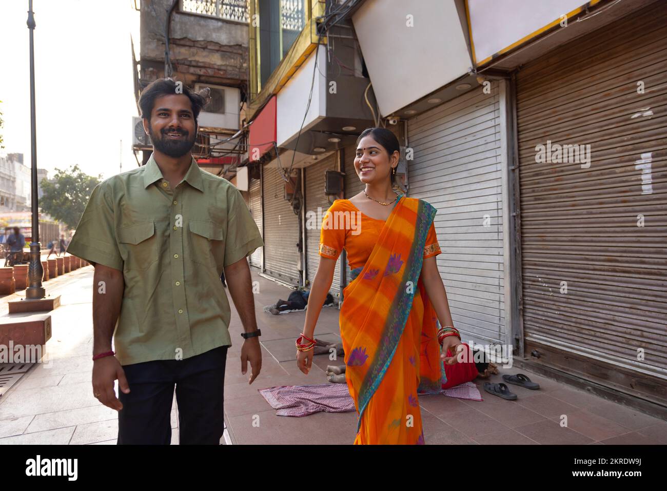 Portrait of young couple together walking on footpath Stock Photo - Alamy